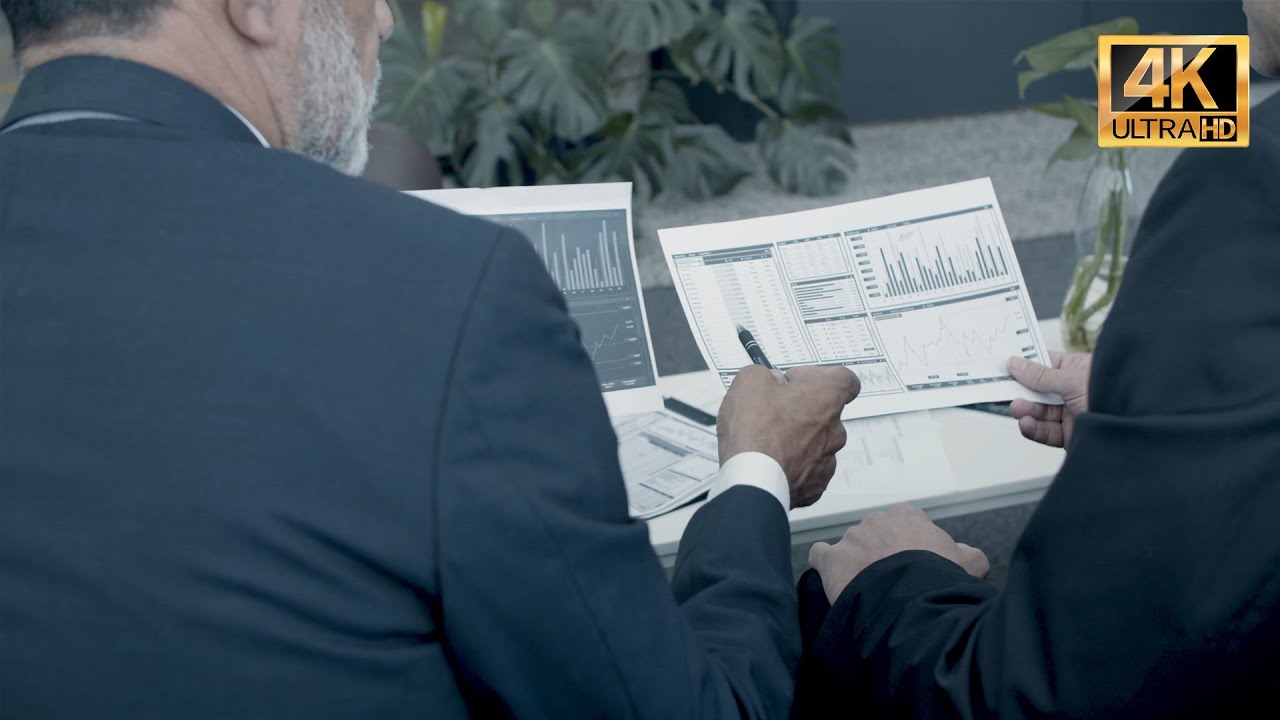 Data-Driven Discussions: Men Analyzing Charts for Performance and Growth | 4K Royalty-Free Video