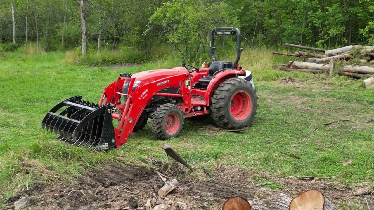 Kubota Tractor and Grapple moving Logs