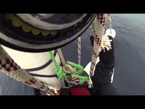 Team Garmin crew member climbs to the top of the mast to fix spinnaker halyard in Pacific Ocean