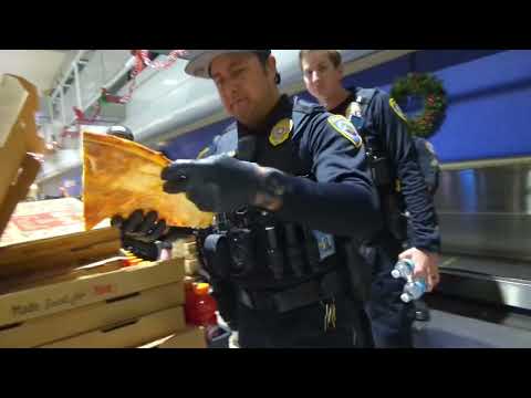 San Diego policemen bring food for the people suffer from Southwest Airline cancellation at midnight