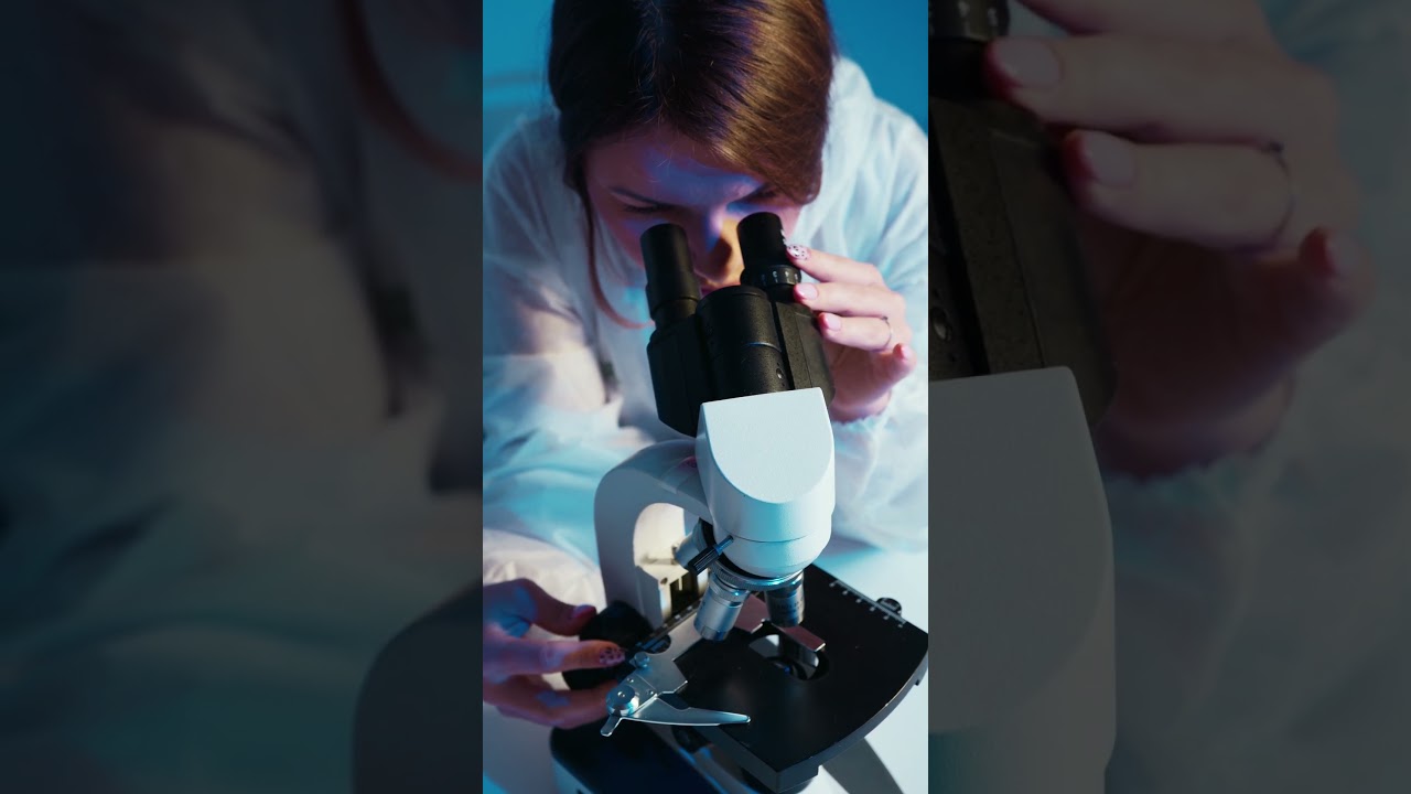 Focused Scientist: Woman Using Microscope for Research | Royalty-Free 4K Stock Footage