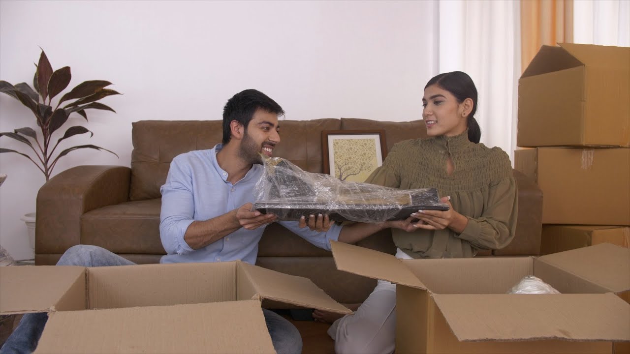A young Indian couple unpacking cardboard boxes for their hous... | Indian Stock Footage | Knot9
