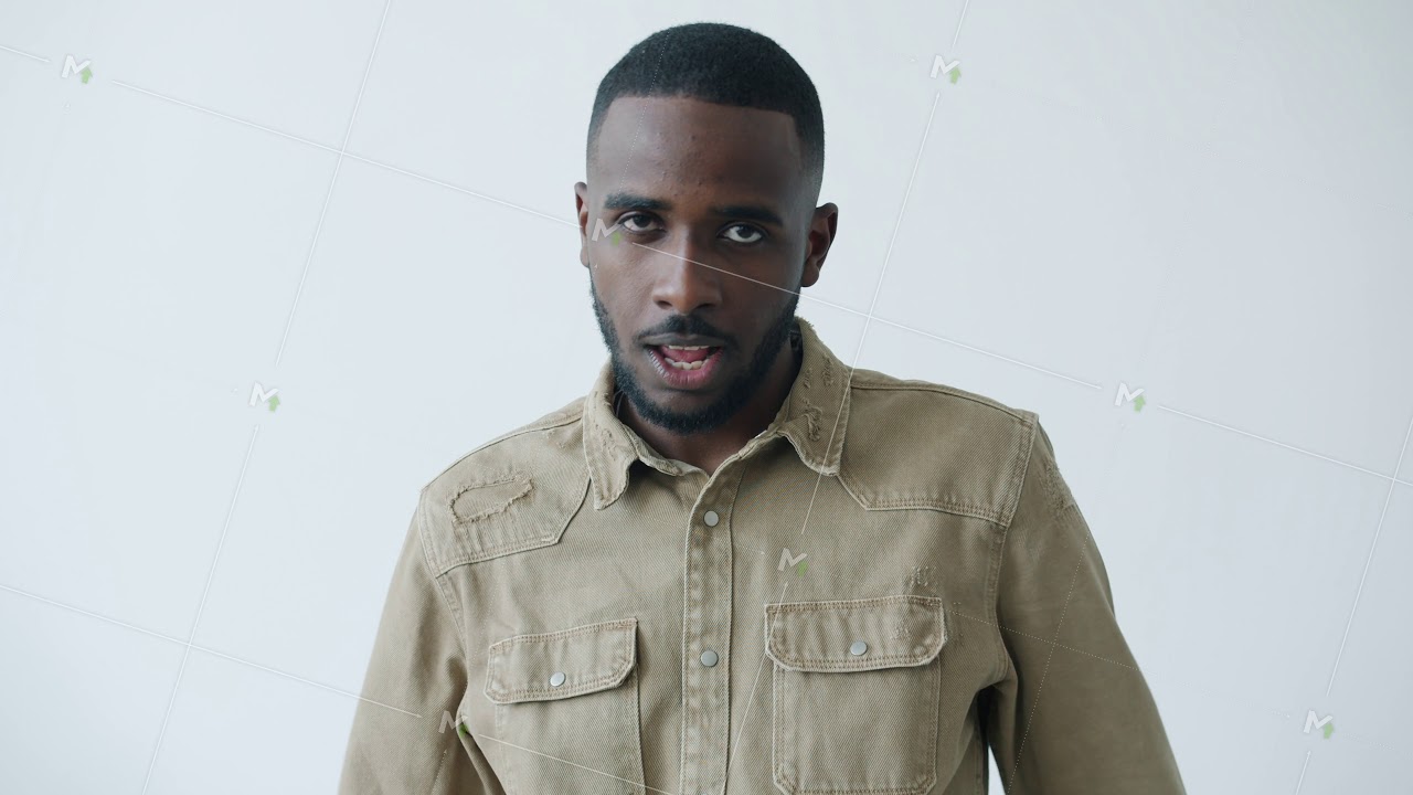 Slow motion of Afro-American guy pointing at himself with thumbs-up gesture and winking