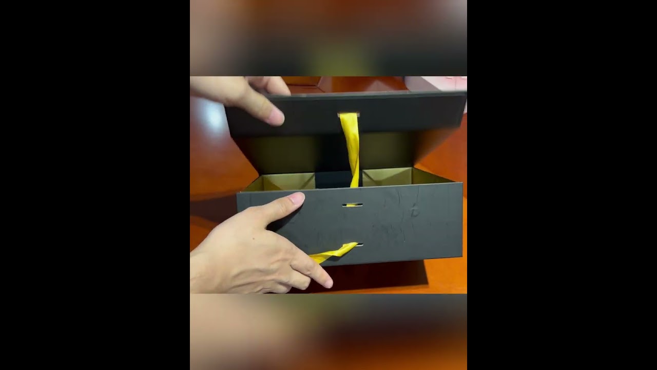 Black folding box with gold ribbon