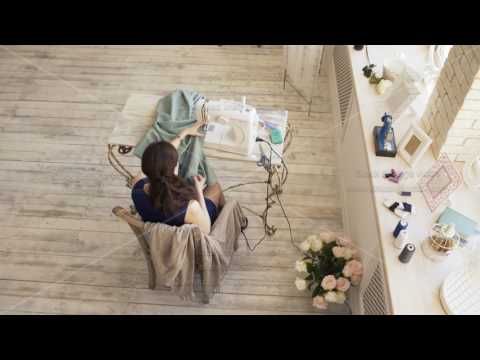 Young clothing designer and seamstress woman work with sewing machine in tailor studio