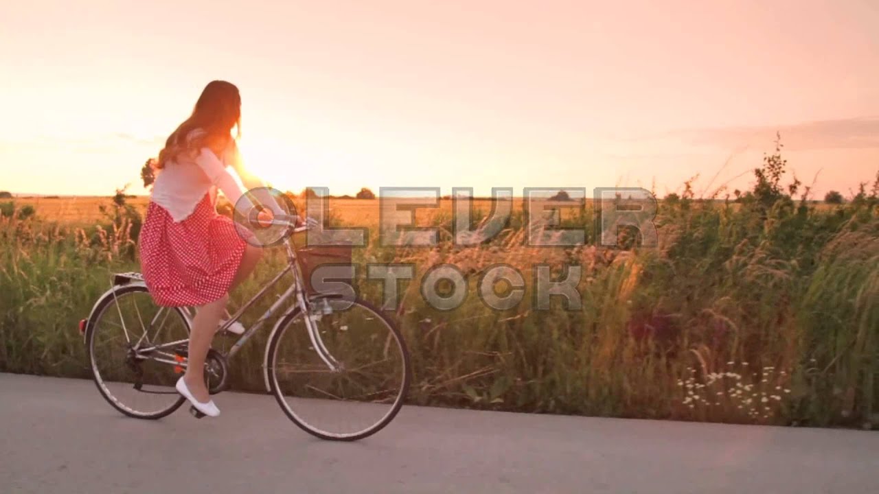 Free Happy Woman Riding Bicycle at Sunset Summer Field - Stock Footage
