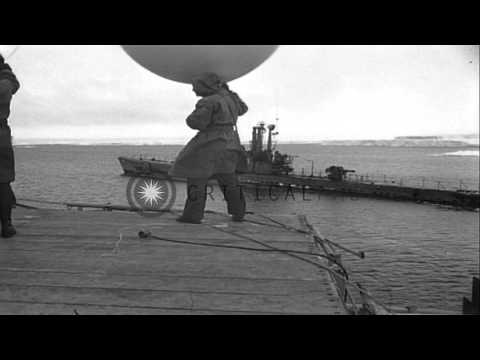 A meteorologist holds a helium-filled balloon and other man holds a radiosonde as...HD Stock Footage