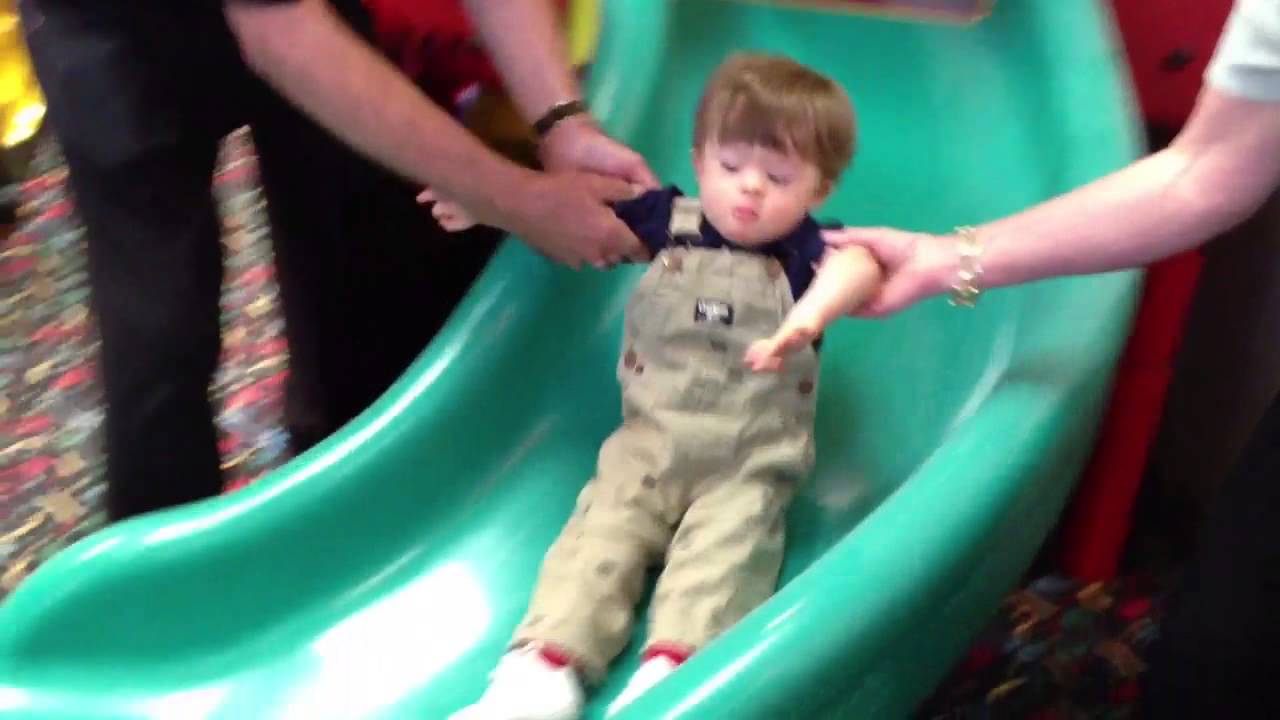 Evan goes on the slide at Chuck E Cheese