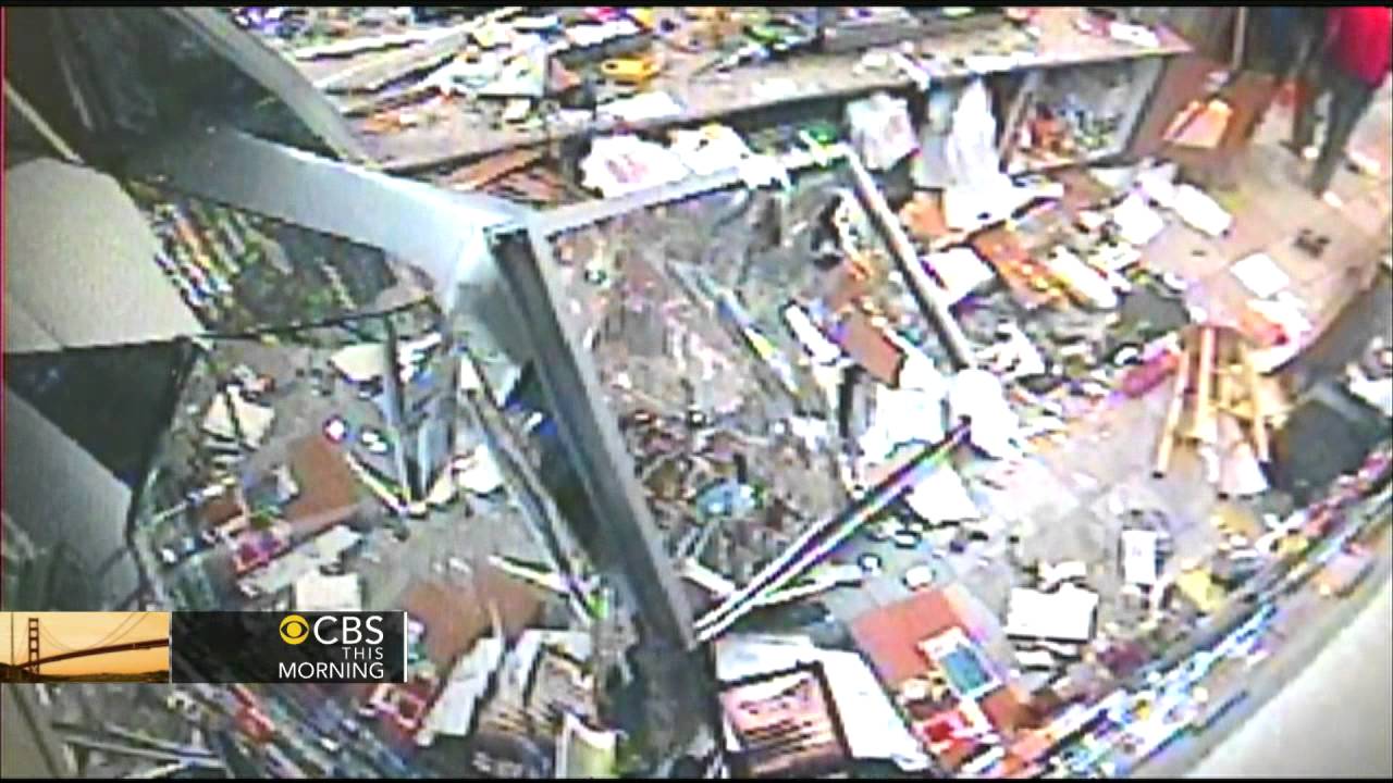 Car crashes through store wall, sends clerk flying
