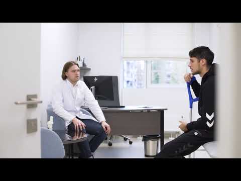 Surgeon Tomas Kadusauskas talking about the patient's treatment with joint injections