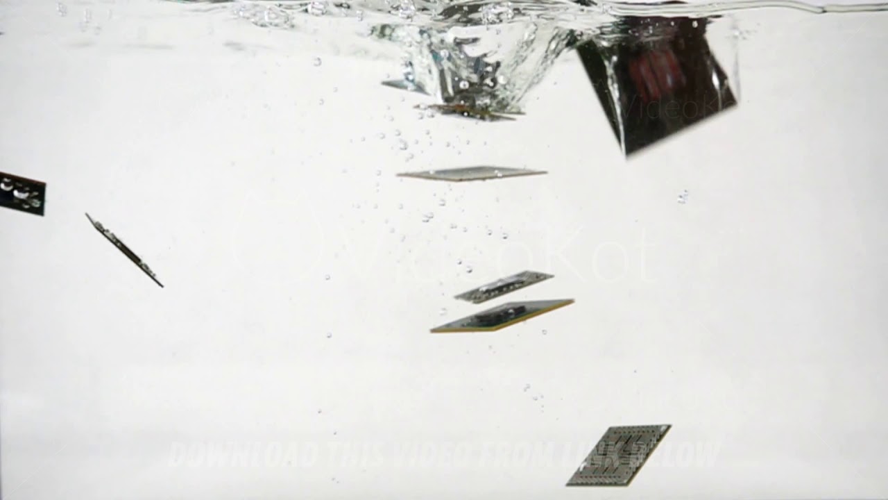 Micro Computer chips fall into the water, slow motion on white background