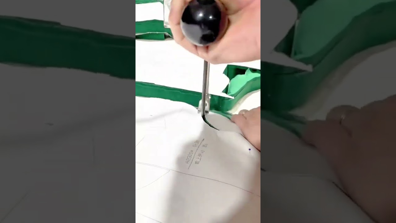 cutting various white and green fabrics specific patterns by using electric cutting machine