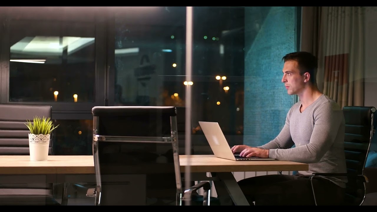 young businessman working on laptop sitting in office late at night