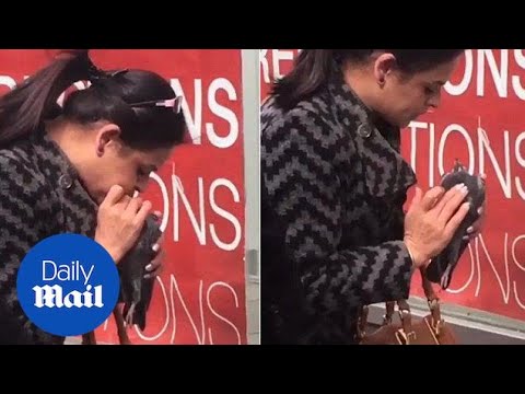 Bizarre moment women resuscitates dead pigeon in the street - Daily Mail