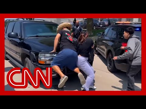Employees block ICE cars with their bodies following meatpacking workplace raid