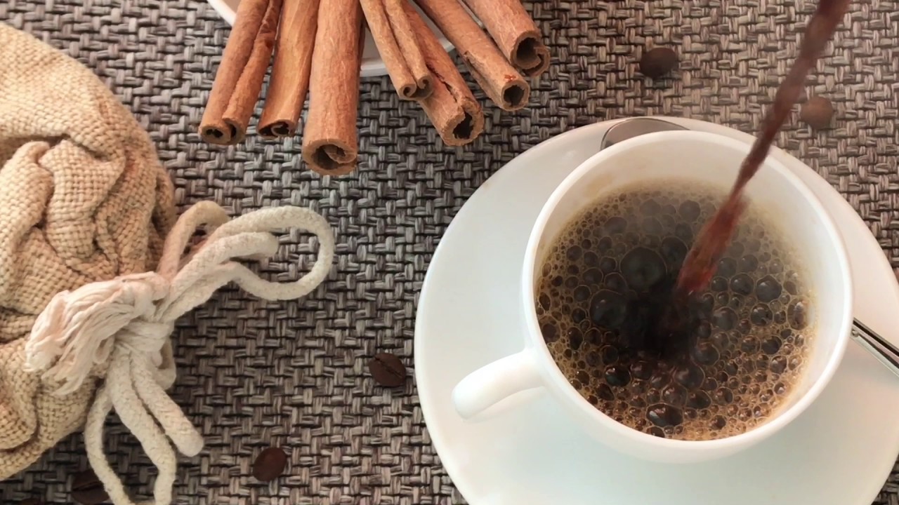 Coffee. A white cup is put on the table, poured hot black with foam, bubbles of aroma steam. Close