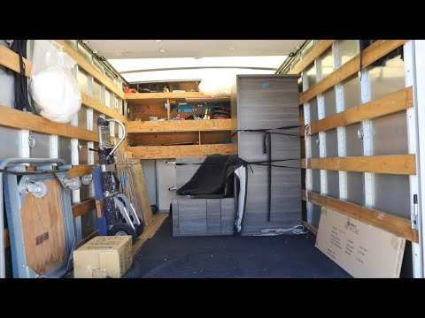 The owner of an office furniture store gives a tour of his furniture delivery trucks