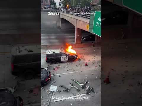Watch moment LA police car set on fire and pelted from overpass in chaotic anti-ICE protests