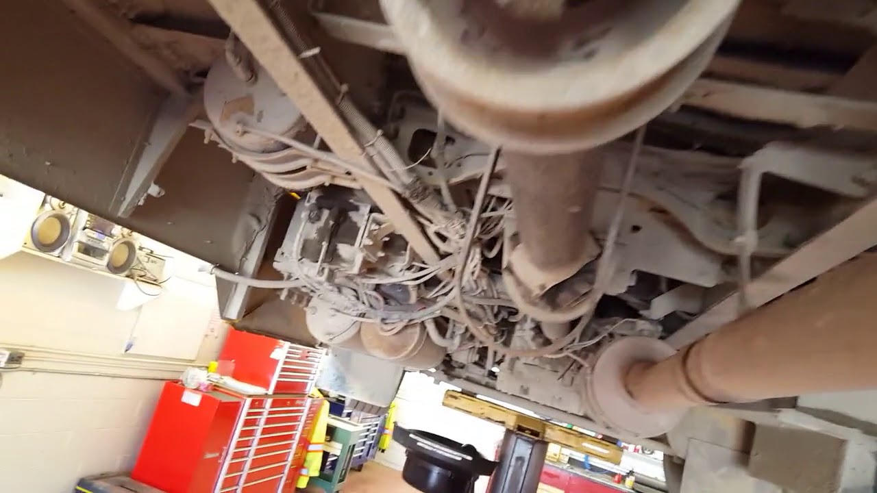 Inspecting School Bus On The Hoist