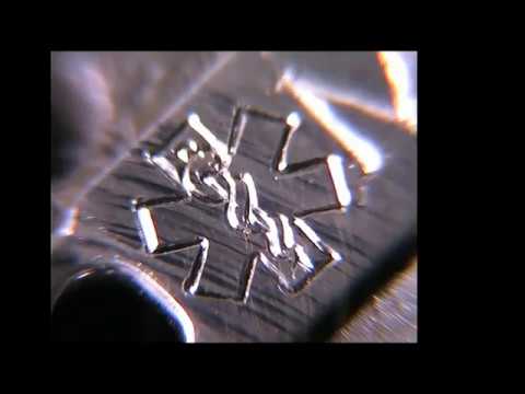 Hand engraving a medical alert symbol closeup