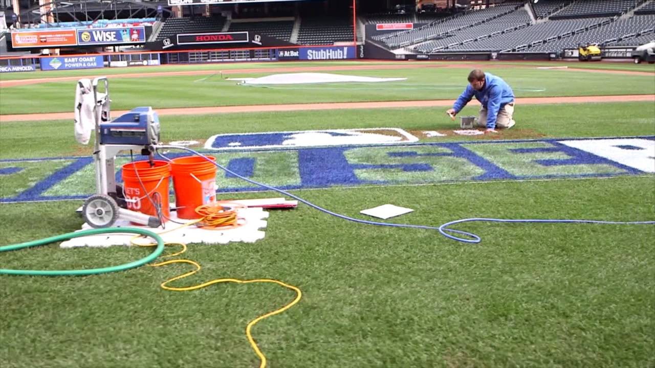 The World Series logo gets painted on the Citi Field grass