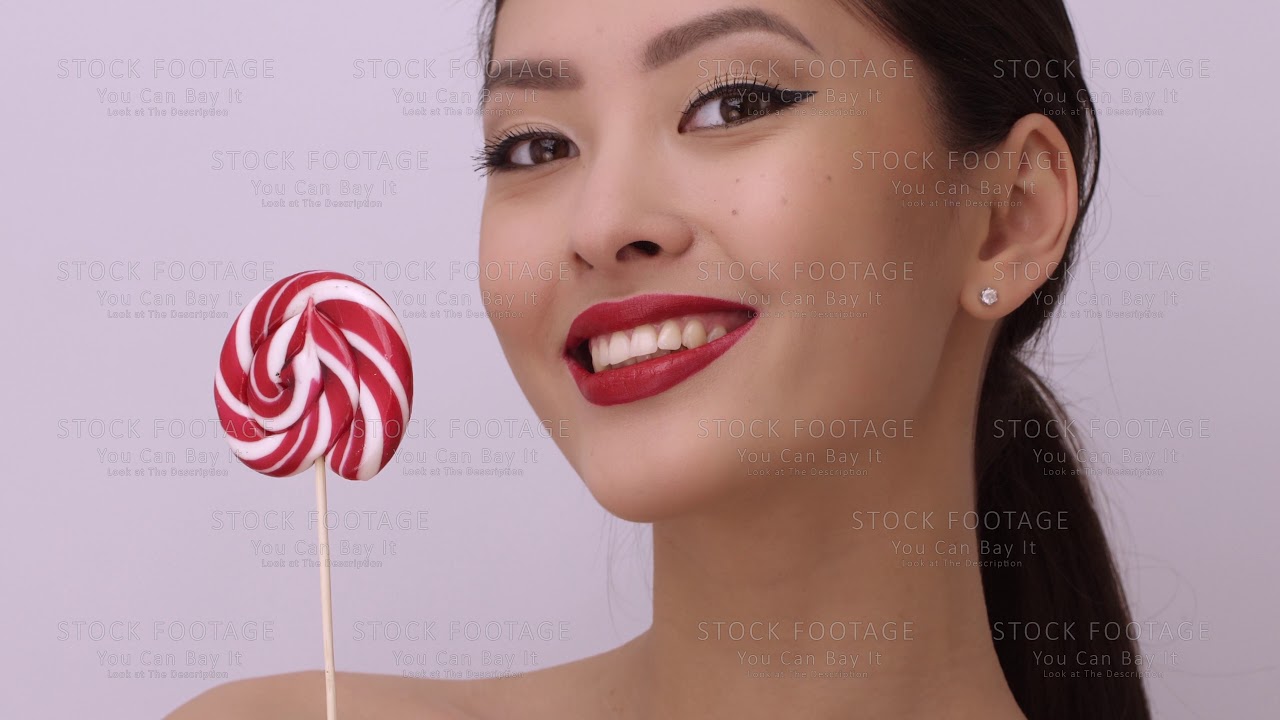 Fashion Portrait of Asian Woman with Lollipop in Studio