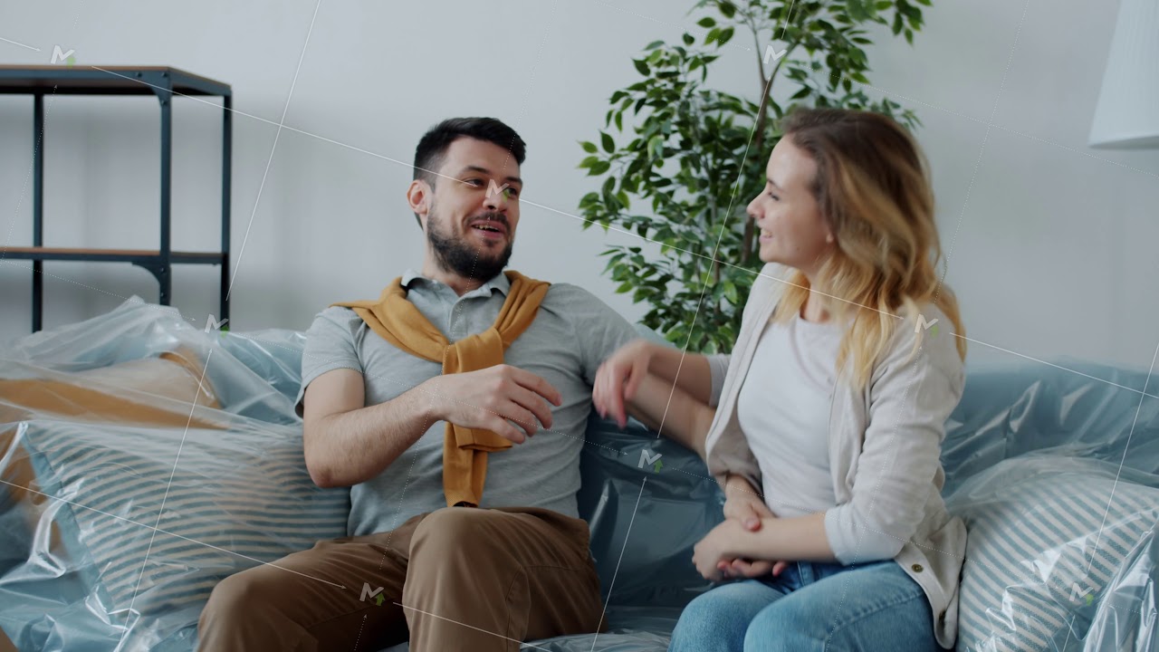 Beautiful couple man and woman carrying boxes during relocation then relaxing kissing hugging