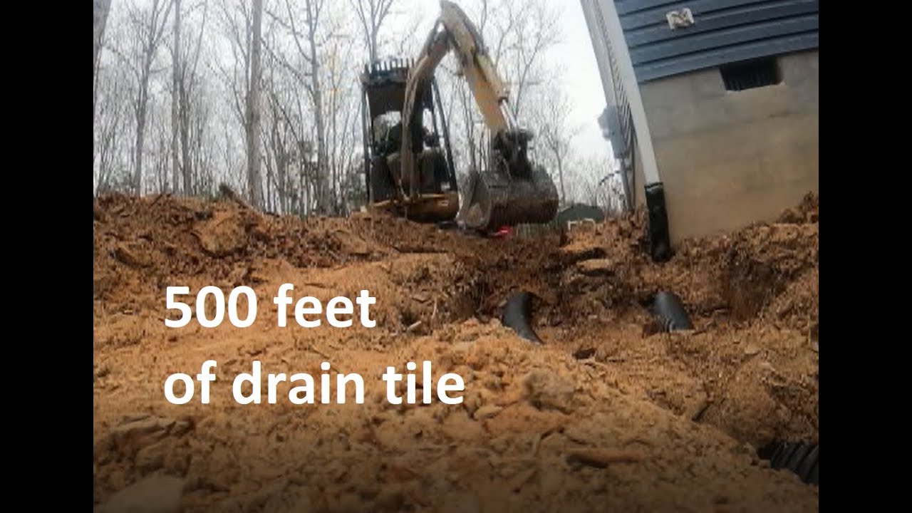 Two landscapers installing 500' drain tile!