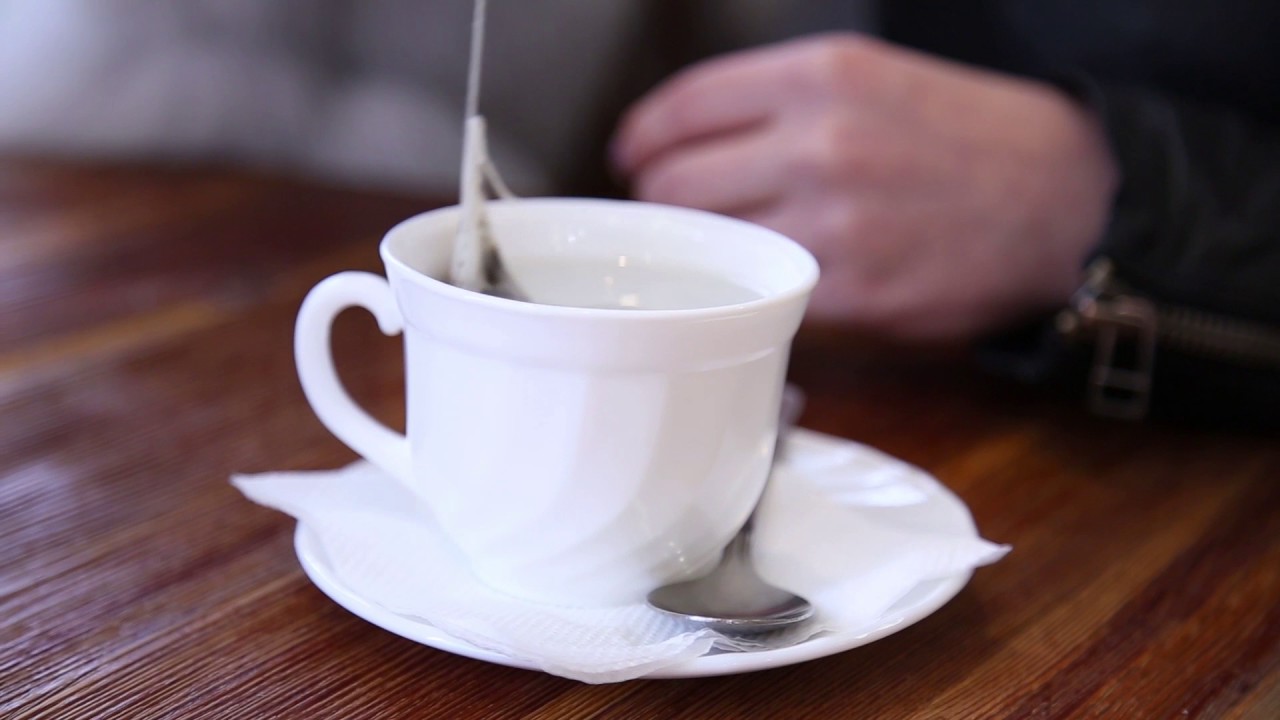 young beautiful woman drinking coffee or a tea in a cafe