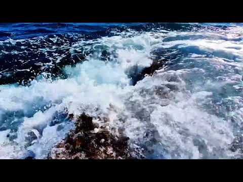 Ocean waves crash against the rugged shoreline, creating a mesmerizing spectacle for all