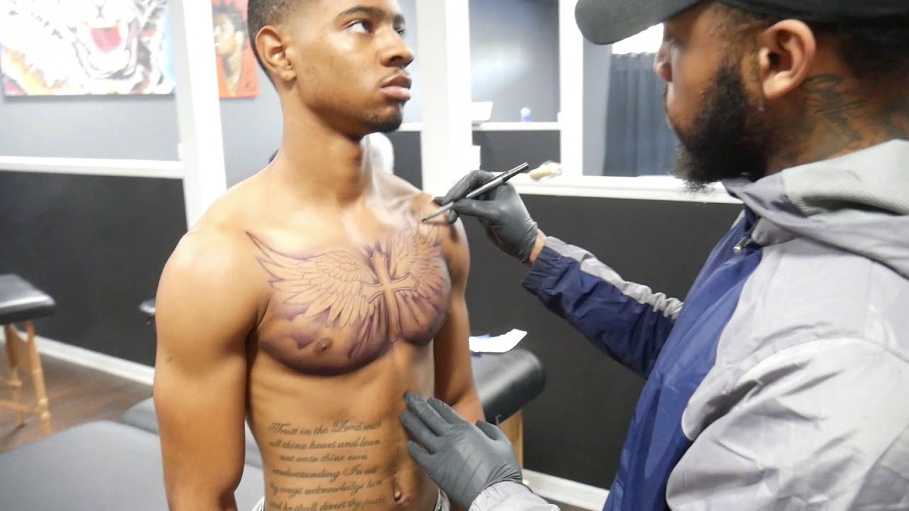 Rell tatts cross with wings on chest
