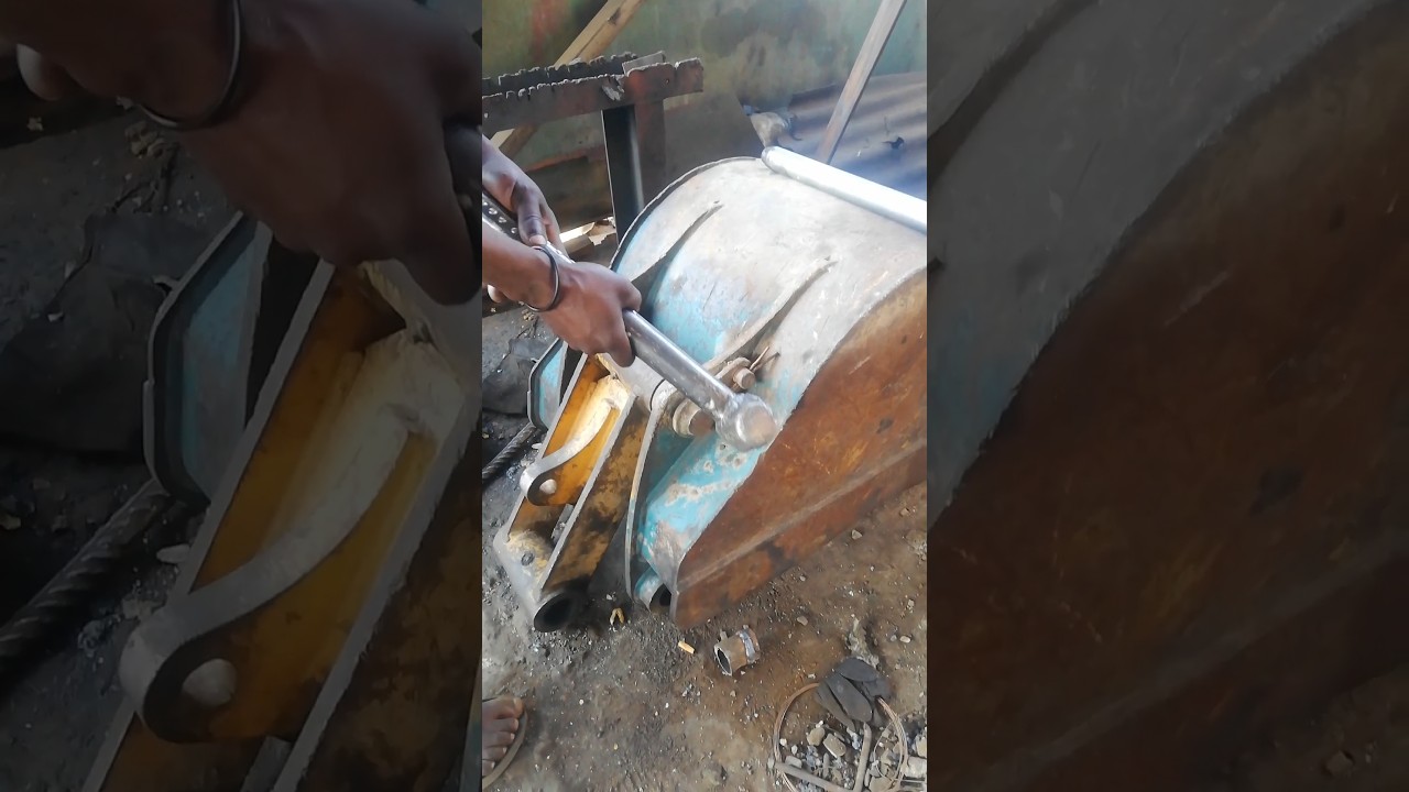 LIGHT HAMMER TAPS TO LOOSEN PIN IN EXCAVATOR'S BUCKET PRIOR REPLACING END BOSS IN WORKSHOP