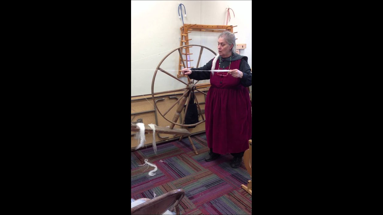 Stephanie Gaustad spinning woolen on a Great wheel walking wheel
