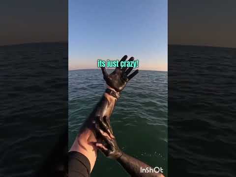 A man rubs squid ink all over his body
