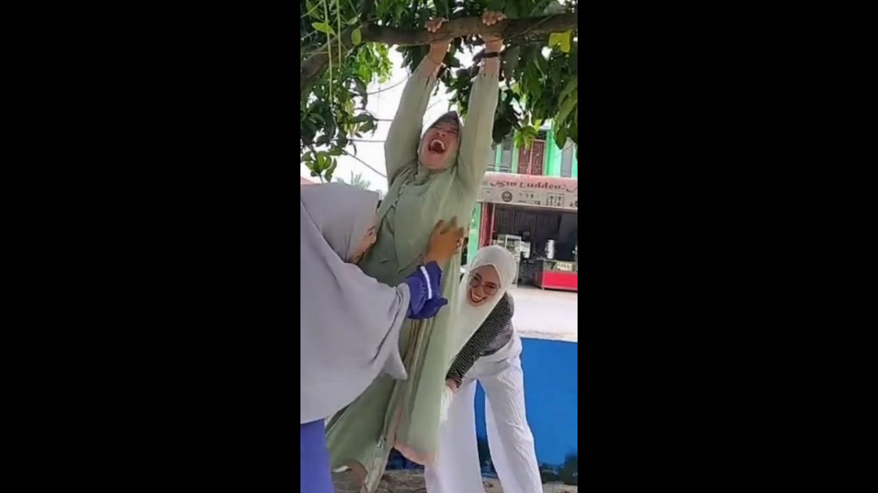 Two girls tickling a girl