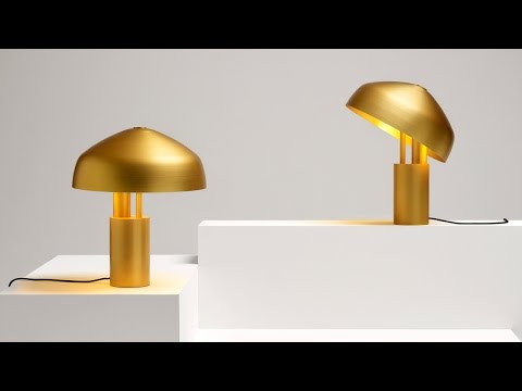 Aura desk lamp by Ross Gardam features a rotating gold shade