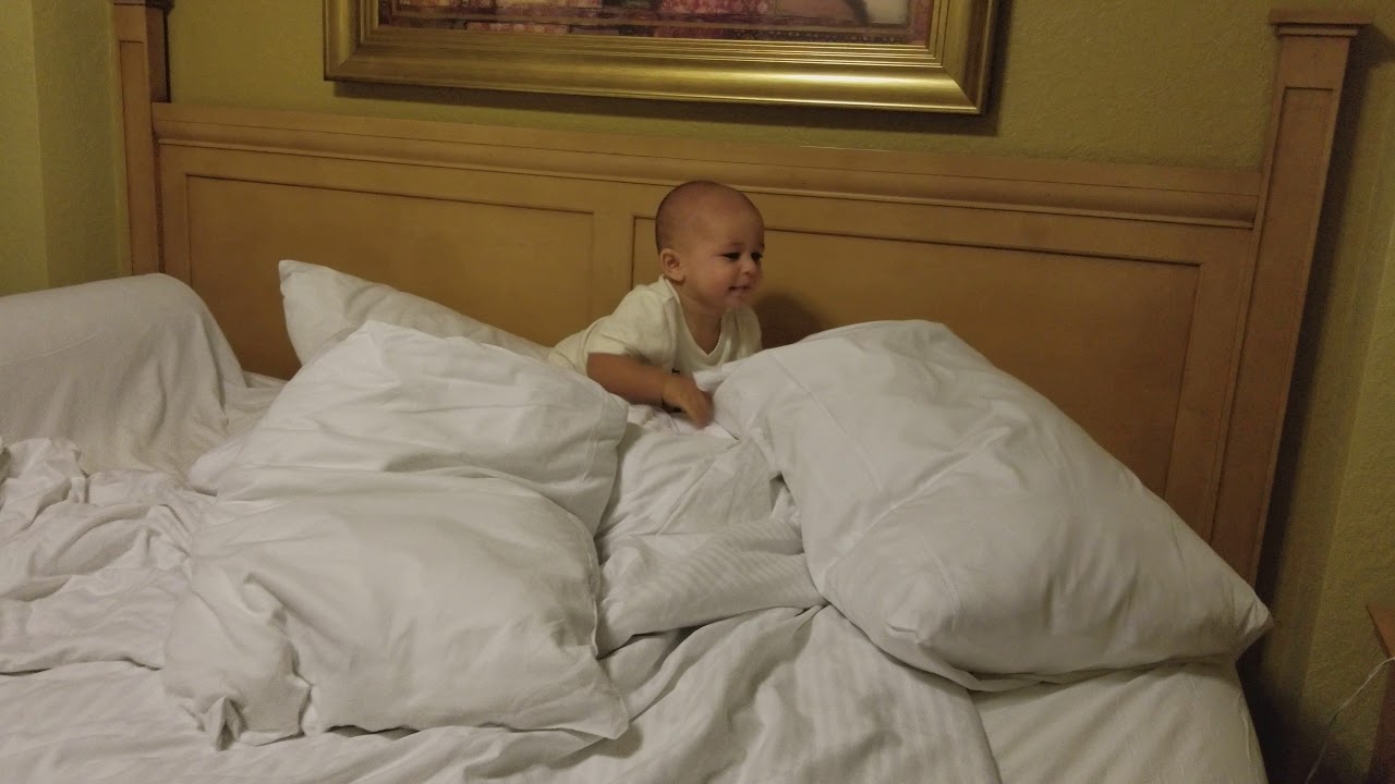Naked Nicky baby playing on the bed