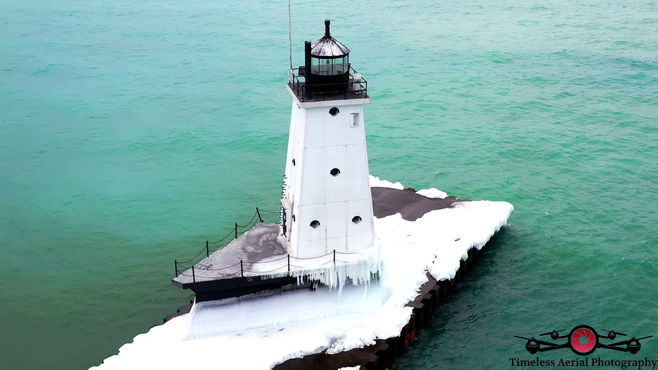 Stunning Frozen View Of Ludington Breakwater Lighthouse & Shoreline 4K Drone Footage Pure Michigan