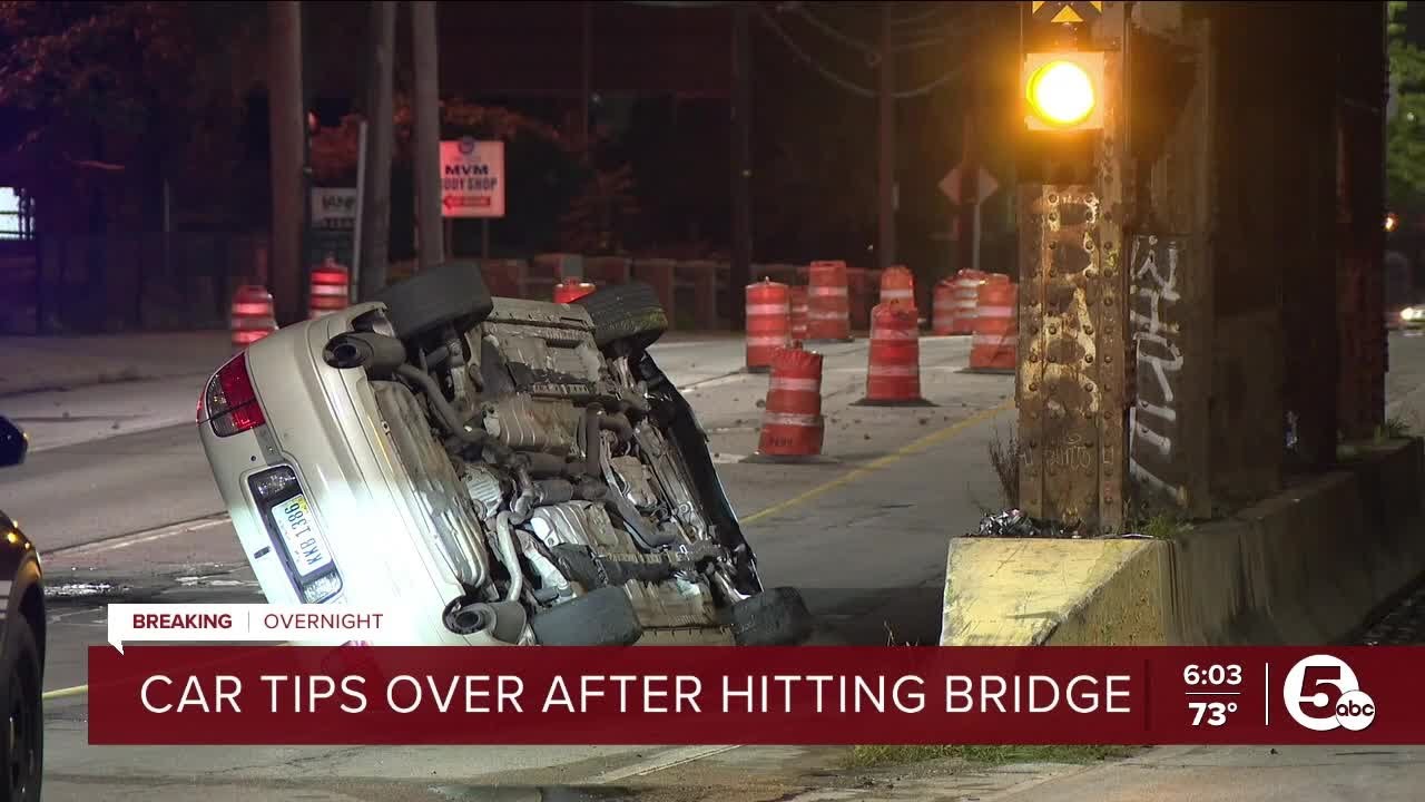 Car tips over after hitting bridge