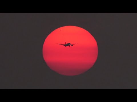 AIRCRAFT PASSING SUN AND LANDING