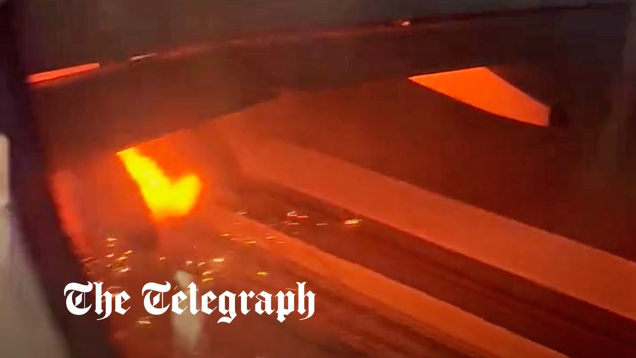Watch: Plane engine bursts into flames as horrified passengers look on