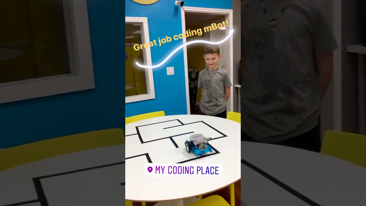 Kid watches his mBot robot travel through a maze using the instructions he coded it to follow.