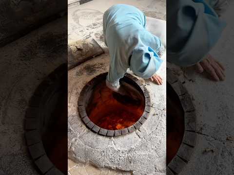 Baking Armenian traditional Lavash bread in old tonir oven
