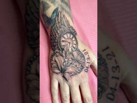 Hand time piece with wings and lilies : birthdate #tattoos #handtattoos