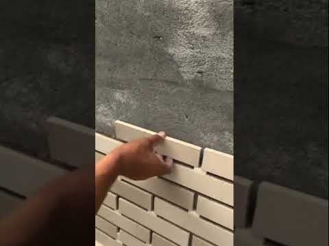 Installing thin brick tiles on a wall.