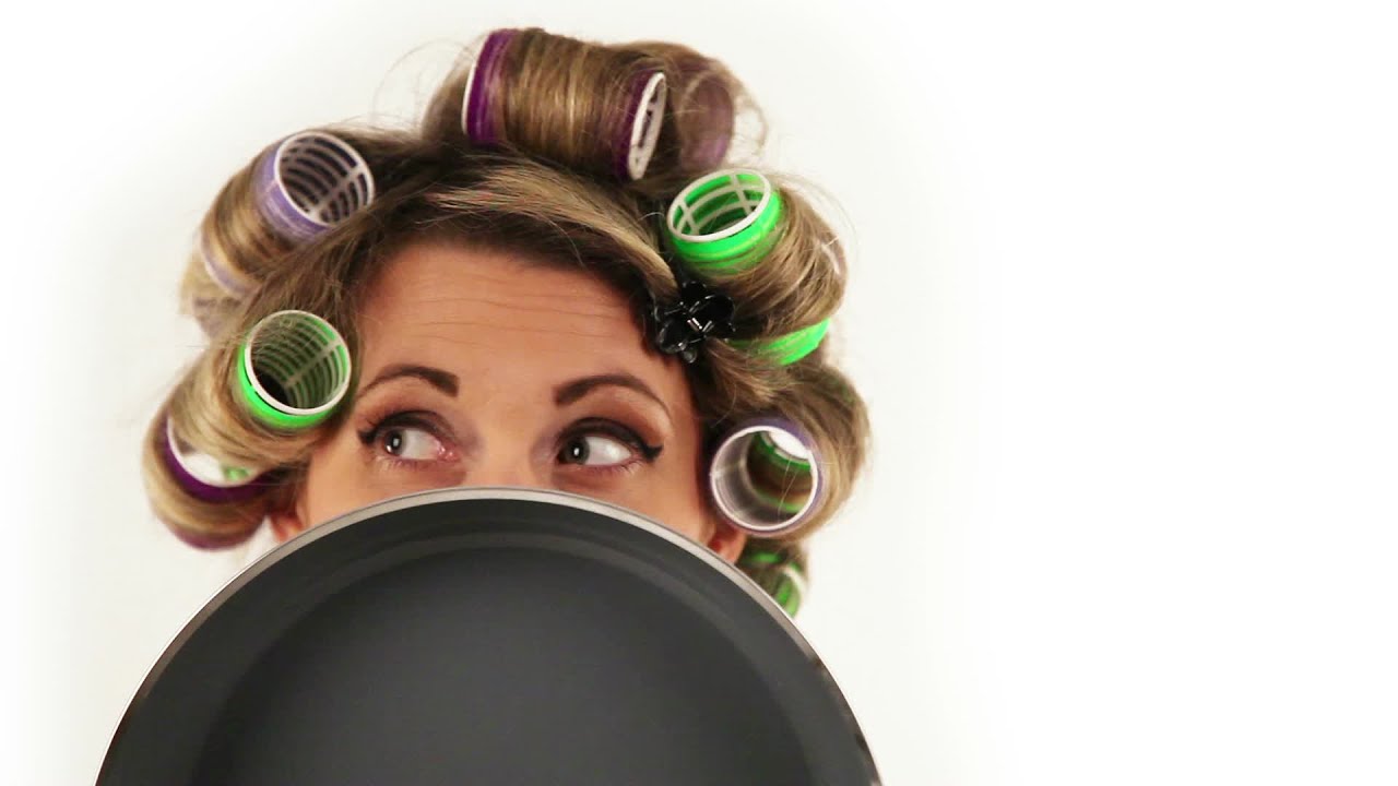 Funny Housewife with hair curlers shoots with eyes. Stock Footage