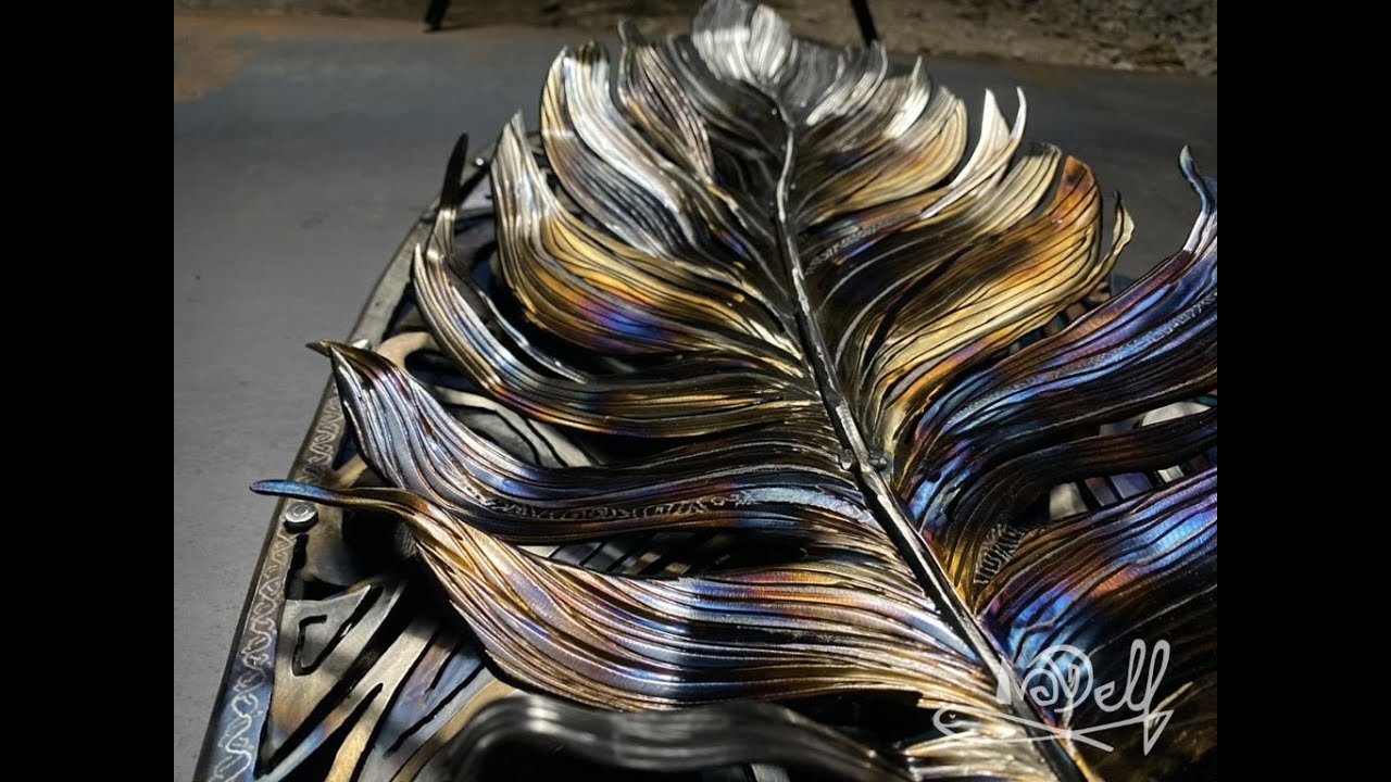 plasma cutting a giant metal feather on a layered background.