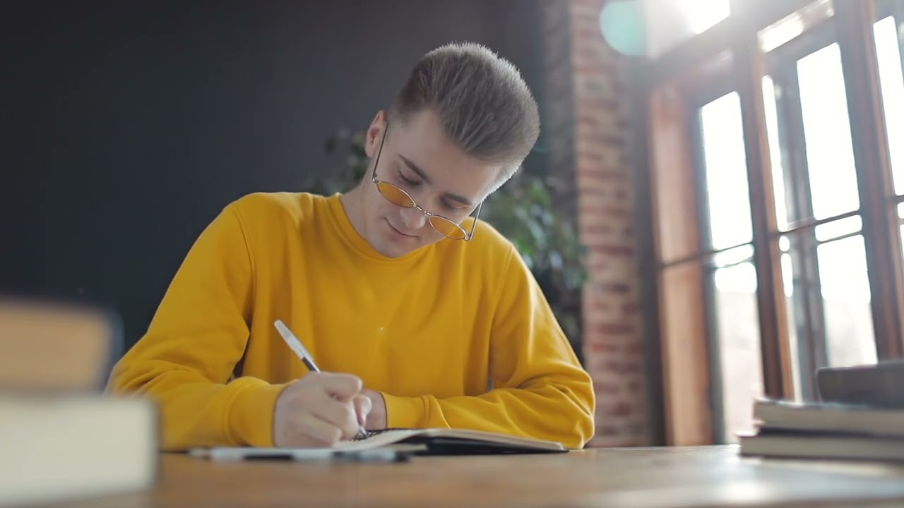 young student writing in a notebook | Free Stock Footage - No Copyright