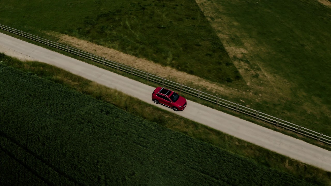 Red SUV driving on country roads, in Flanders, Belgium
