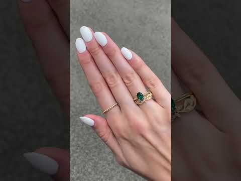 Oval cut green emerald engagement ring in a cathedral design & leaf design wedding band